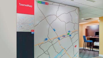 Um mapa com nomes de ruas e localidades, um sinal vermelho com o texto 'TowneMap' e um quarto com escrivaninha e cadeira.