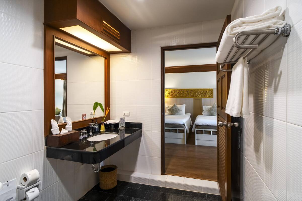 Uma casa de banho moderna com um espelho grande, uma pia e zona de duche.