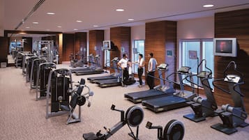 Academia com esteiras, elípticos e equipamentos de musculação.