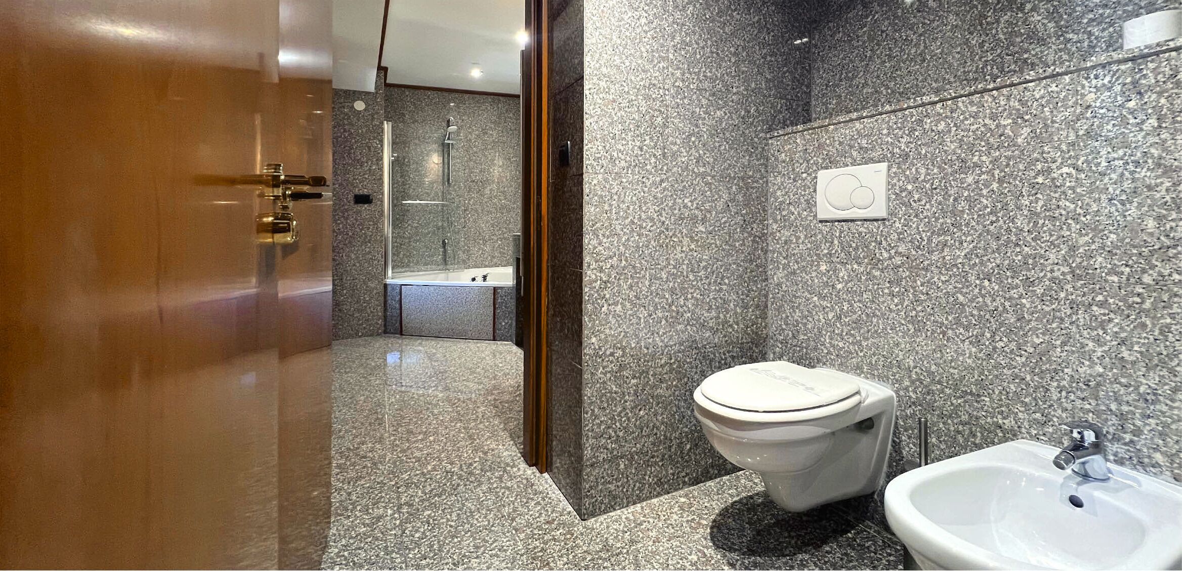 Casa de banho moderna com sanita, lavatório e zona de duche.