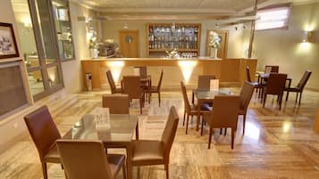 Um restaurante com área de bar, cadeiras de madeira e piso de mármore.