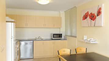 Apartamento, 2 quartos | Cozinha privada | Geladeira grande, micro-ondas, fogão, cooktop