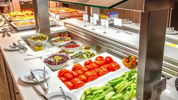 Um buffet com diversos alimentos e utensílios.