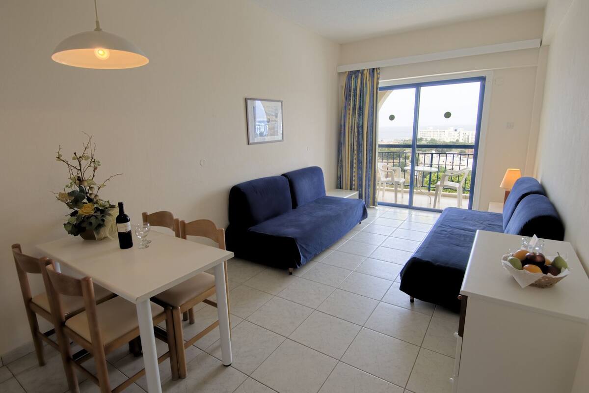 Uma sala de estar moderna com área de jantar, sofá e varanda com vista.