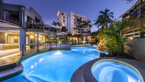 Um hotel com piscina, área de estar ao ar livre e vista para os edifícios próximos.