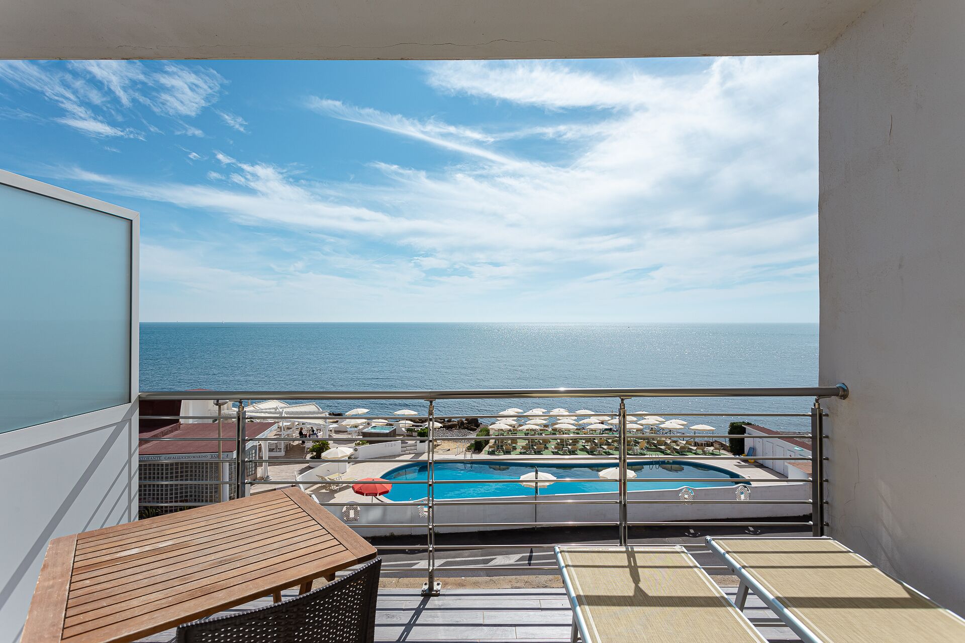 Varanda com vista para o mar e área de piscina.