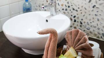 Uma casa de banho com uma pia branca, um espelho redondo e uma parede decorativa com padrão pontilhado.