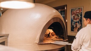 Forno de pizza a lenha em cozinha profissional.