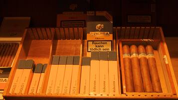 Uma caixa de charutos de madeira com várias marcas e tipos de charutos, incluindo 'Siglo II' e 'Robustos'.