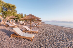 Na praia, espreguiçadeiras, guarda-sóis, bar na praia