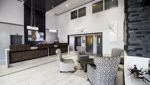 Uma área de recepção moderna, com balcão, espaço para sentar e parede decorativa.