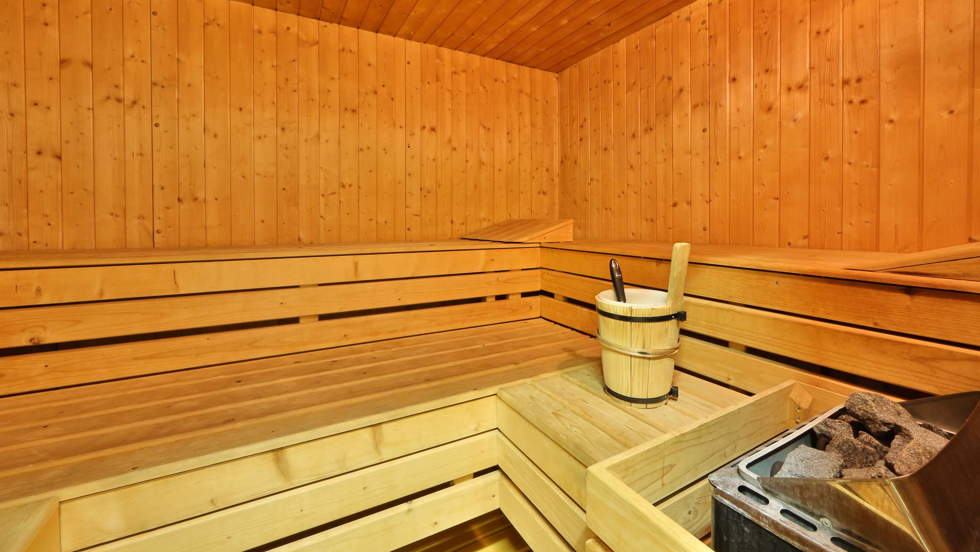 Uma sauna com bancos de madeira e uma bacia de pedra.