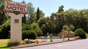 Placa de motel com o nome 'Townhouse Motel' e indicações de 'Showtime' e 'Preços de Pousada'.