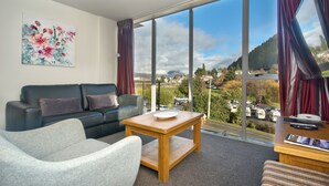 Uma sala de estar moderna com sofá, poltrona e mesa de madeira.