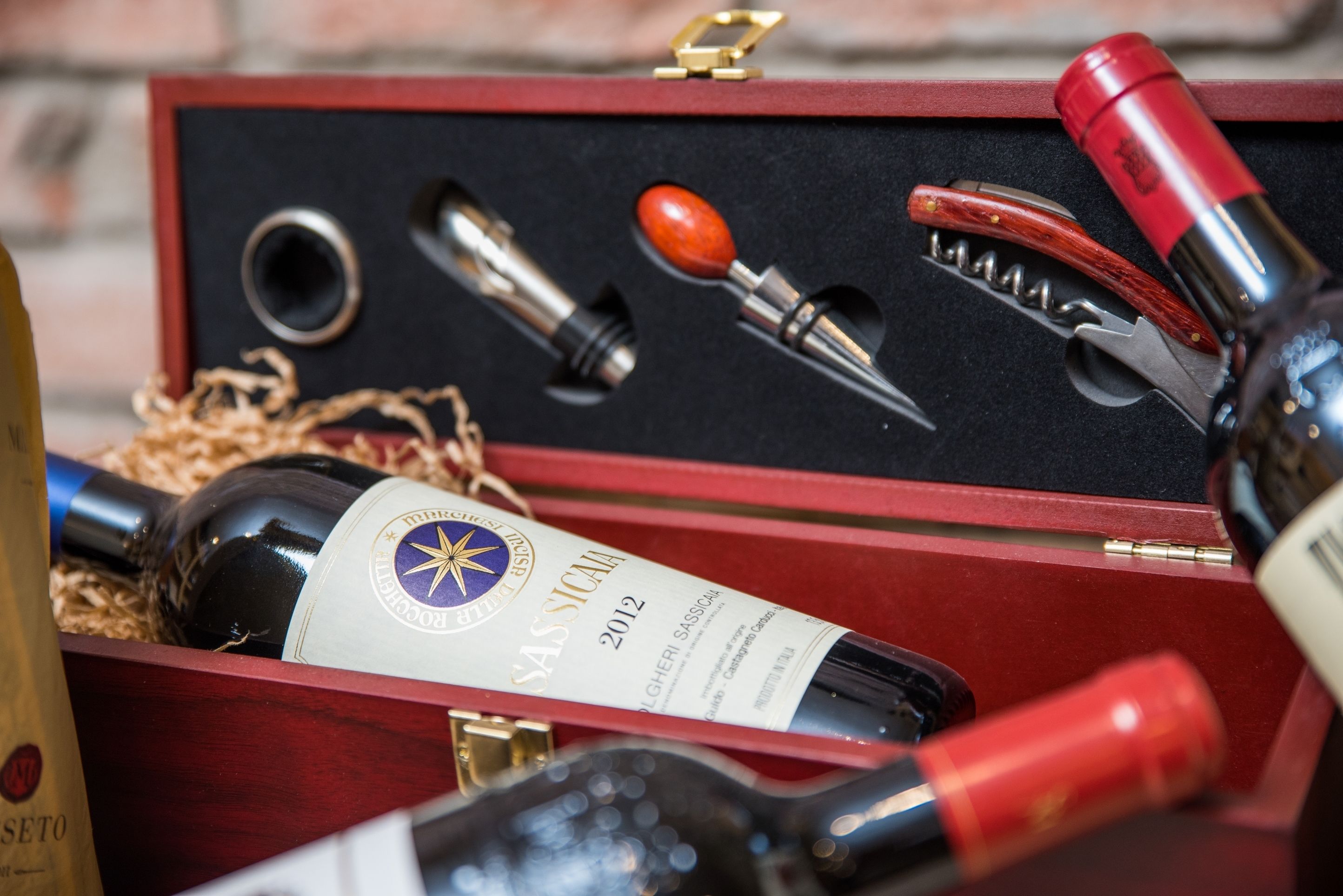 Uma garrafa de vinho em uma caixa com rolhas e saca-rolhas.