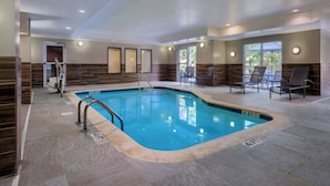 Piscina interior com profundidade de 1,2 metros, rodeada por espreguiçadeiras e piso revestido de azulejos.