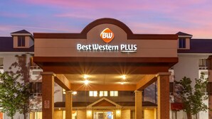 Exterior do hotel Best Western PLUS, com céu limpo e um letreiro sobre a entrada.