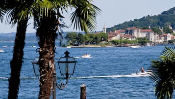 Uma vila costeira com barcos na água, um farol e edifícios com telhados vermelhos.
