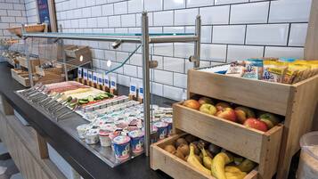 Buffet com diversos alimentos e utensílios.