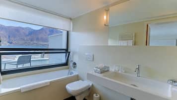 Uma casa de banho moderna com banheira, sanita e lavatório.