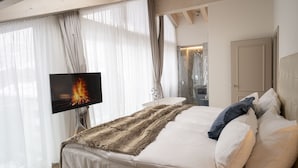 Quarto com cama grande, televisão de tela plana e lareira.