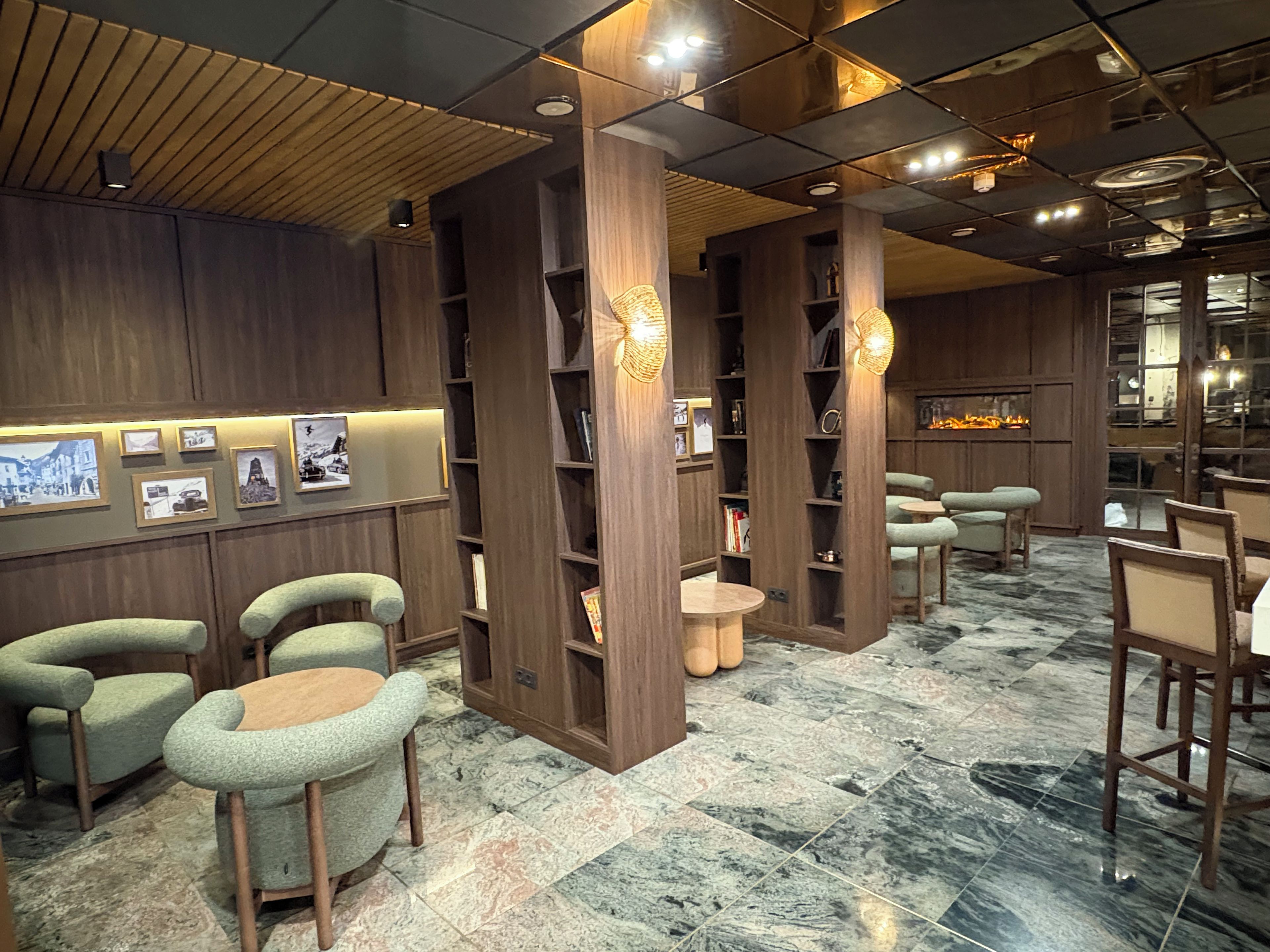 Um interior moderno com painéis de madeira, estantes de livros e áreas de estar.