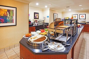 Disposição de buffet com diversos alimentos e utensílios.