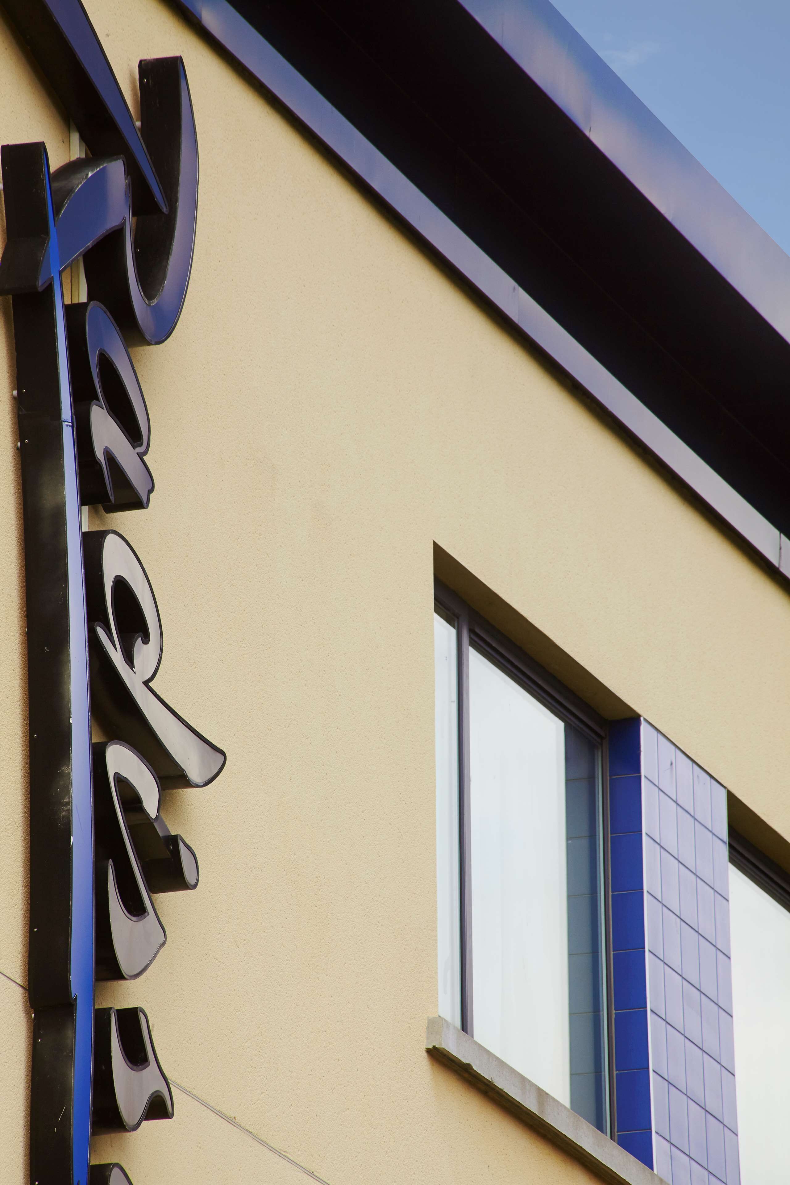 Fachada de edifício com uma placa grande que diz 'Park Inn'.