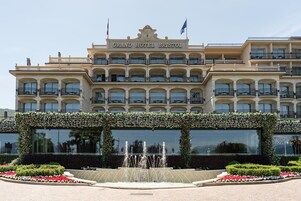 Um hotel grande com várias varandas e uma fonte central.
