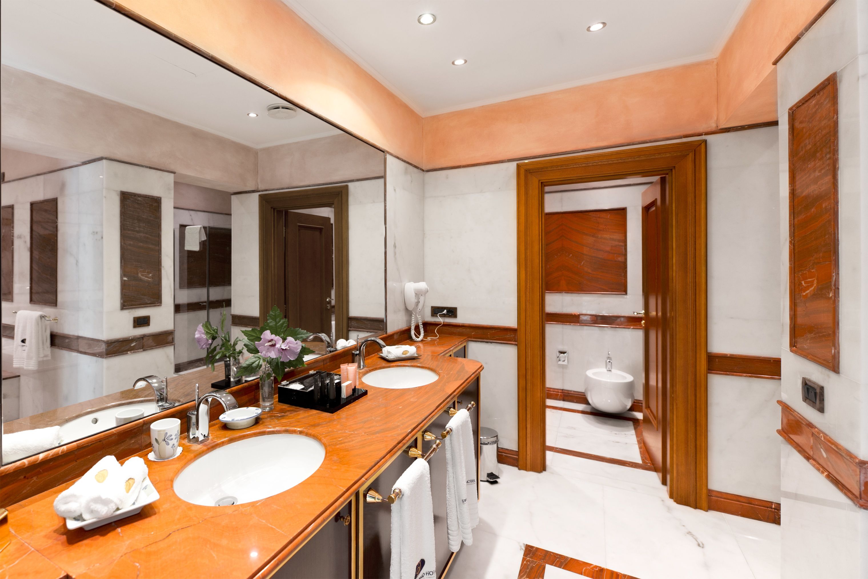 Uma casa de banho moderna com duas bacias, um espelho grande e um espaço de toucador.
