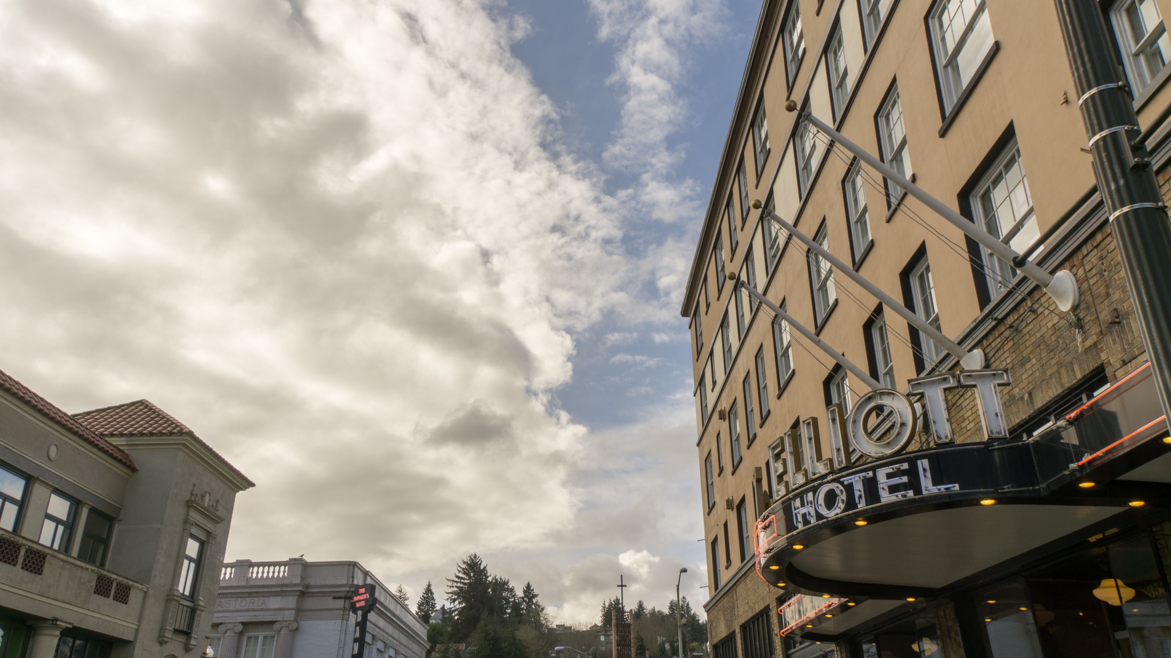 Hotel com estilo arquitetônico clássico, destacando uma placa e uma varanda.