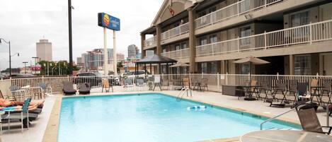 Um hotel com área de piscina, espaço ao ar livre e vista para o horizonte da cidade.