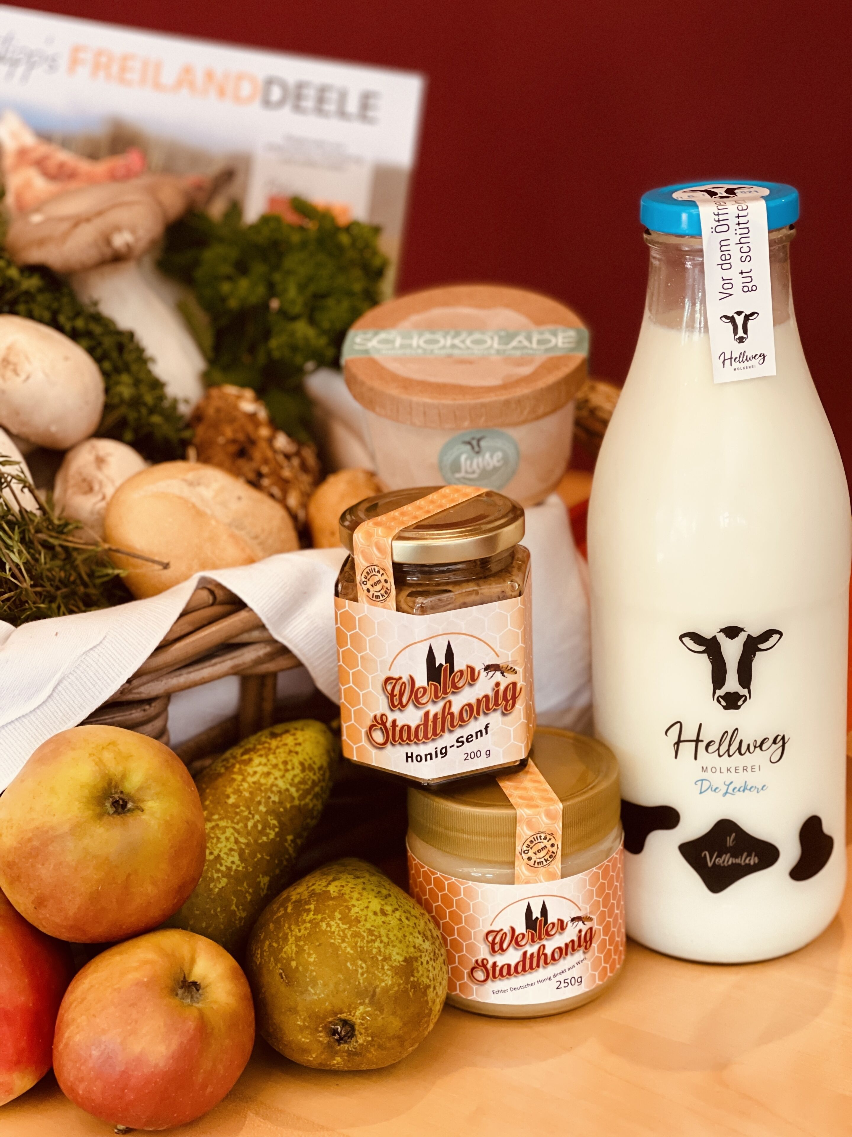 Diversos alimentos, como maçãs, cogumelos, potes de mel e leite.
