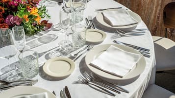 Uma mesa posta para refeição, com pratos, talheres e copos.