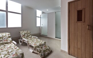 Quarto com cama, cadeira e porta de madeira.