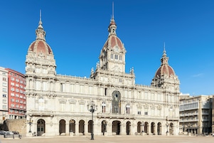 Um edifício imponente e histórico, com várias cúpulas e arcos, provavelmente um marco público ou cultural importante.