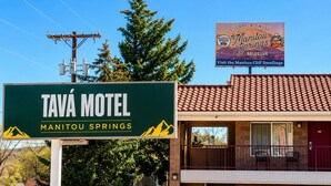 Placa de motel e um edifício com telhado de azulejos e varanda.