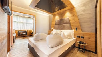 Quarto moderno com uma cama grande, uma mesinha e uma cadeira.