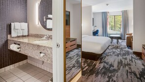 Quarto de hotel com banheiro, cama, escrivaninha e vista para o exterior.