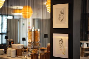 Decoração moderna com obras de arte emolduradas na parede, um espaço para café e uma área de refeições bem iluminada.