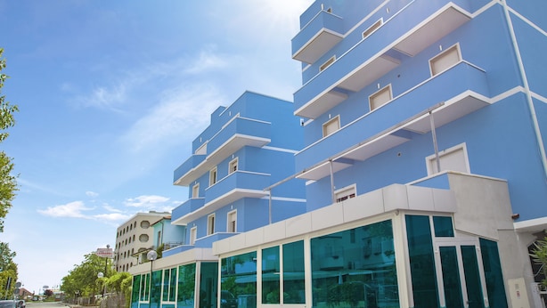 Um edifício moderno, de vários andares, com varandas e grandes janelas.