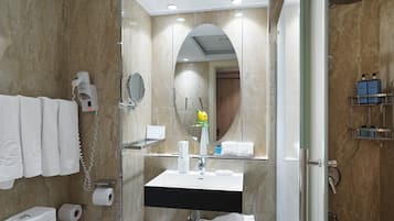 Uma casa de banho moderna com lavatório, espelho e chuveiro.
