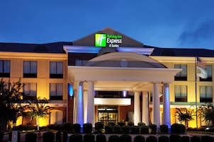Edifício Holiday Inn Express & Suites com entrada destacada, colunas e céu claro.