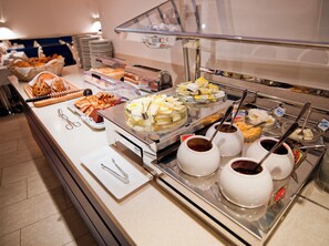 Buffet com diversos alimentos e acompanhamentos.
