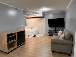 Quarto solteiro romântico, 1 cama King, banheira de imersão, vista para a montanha | Área de estar | TV de tela plana 32 polegadas com canais a cabo, TV
