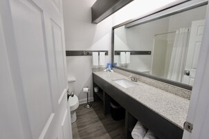 Quarto Deluxe, 1 cama king-size | Casa de banho | Uma combinação polibã/banheira, artigos de higiene pessoal grátis