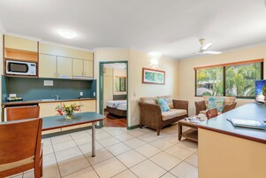 Um espaço compacto com cozinha compacta, área de jantar, sofá e cama.