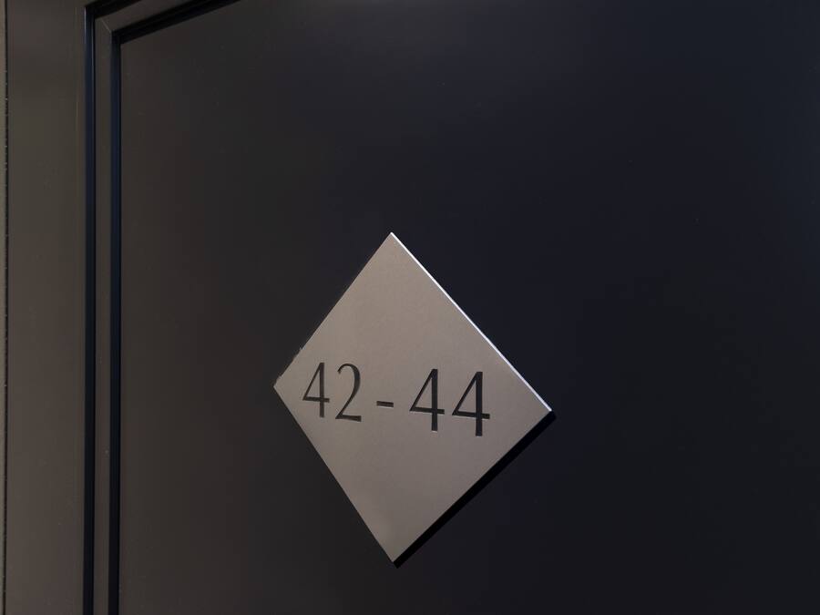 Uma placa metálica com os números '42-44' indicando números de quartos.