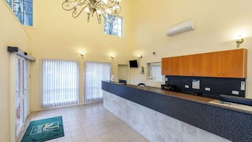 Cozinha ampla com bancada comprida, armários de madeira e lustre.