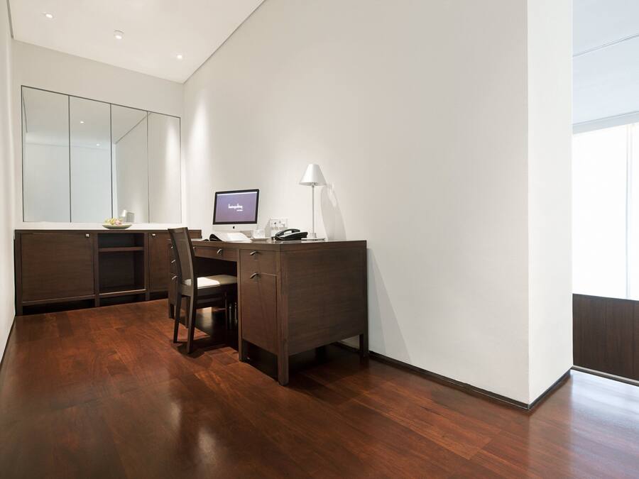 Um espaço de escritório moderno com uma mesa, cadeira e computador.
